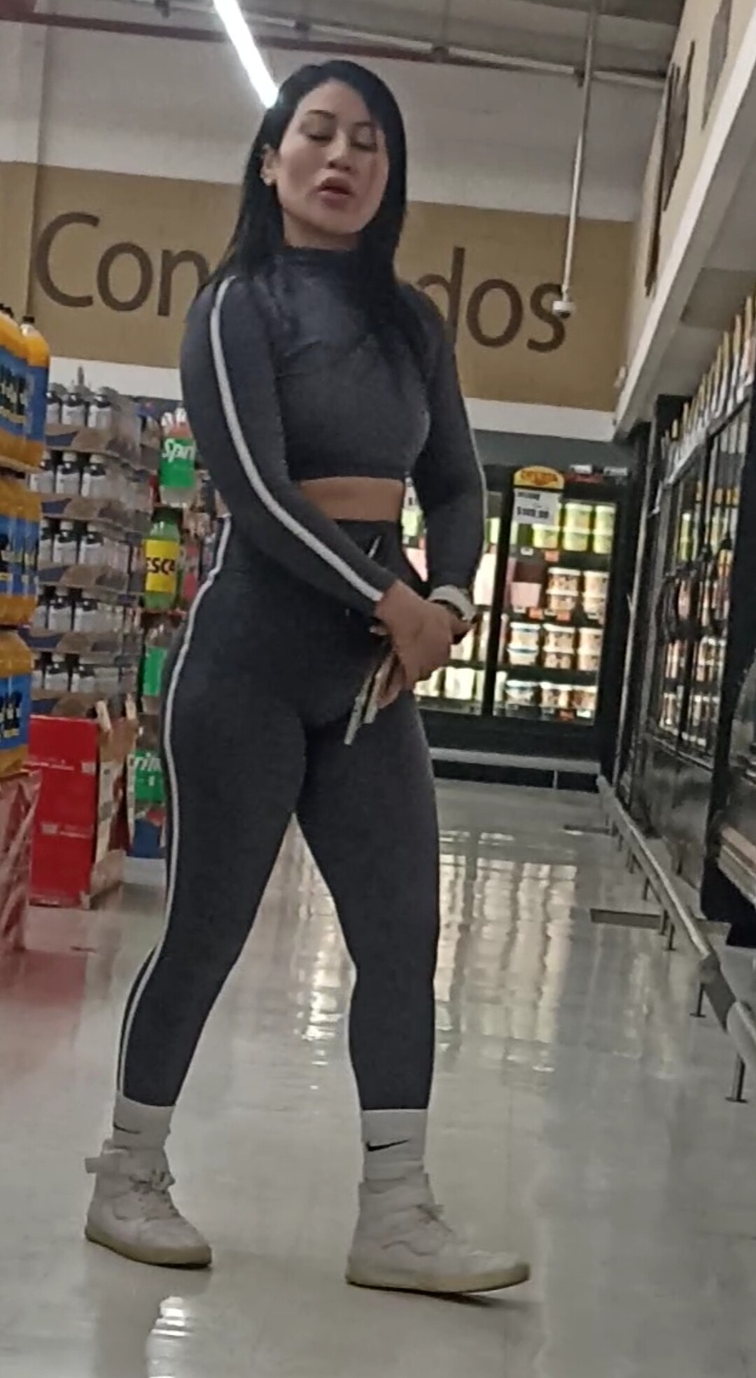 Fit girl with surgery with a perfect goddess body in very tight gray ...